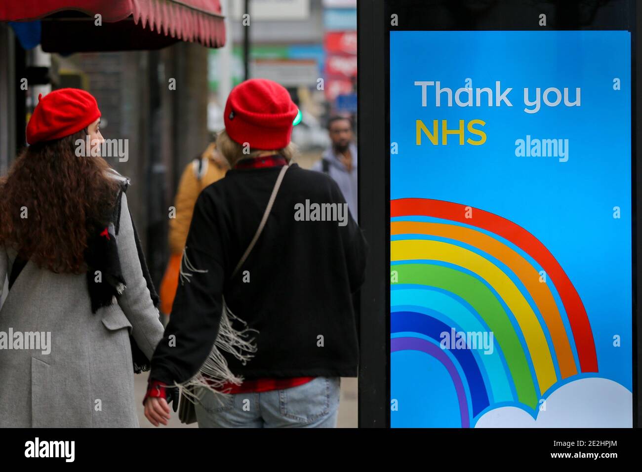 Women walk past' Thank you NHS' publicity campaign poster in London, as ...