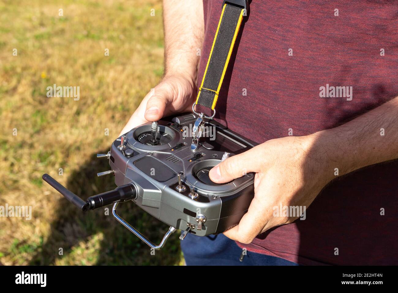 Hands holding a radio remote control transmitter. Toy airplane piloting ...