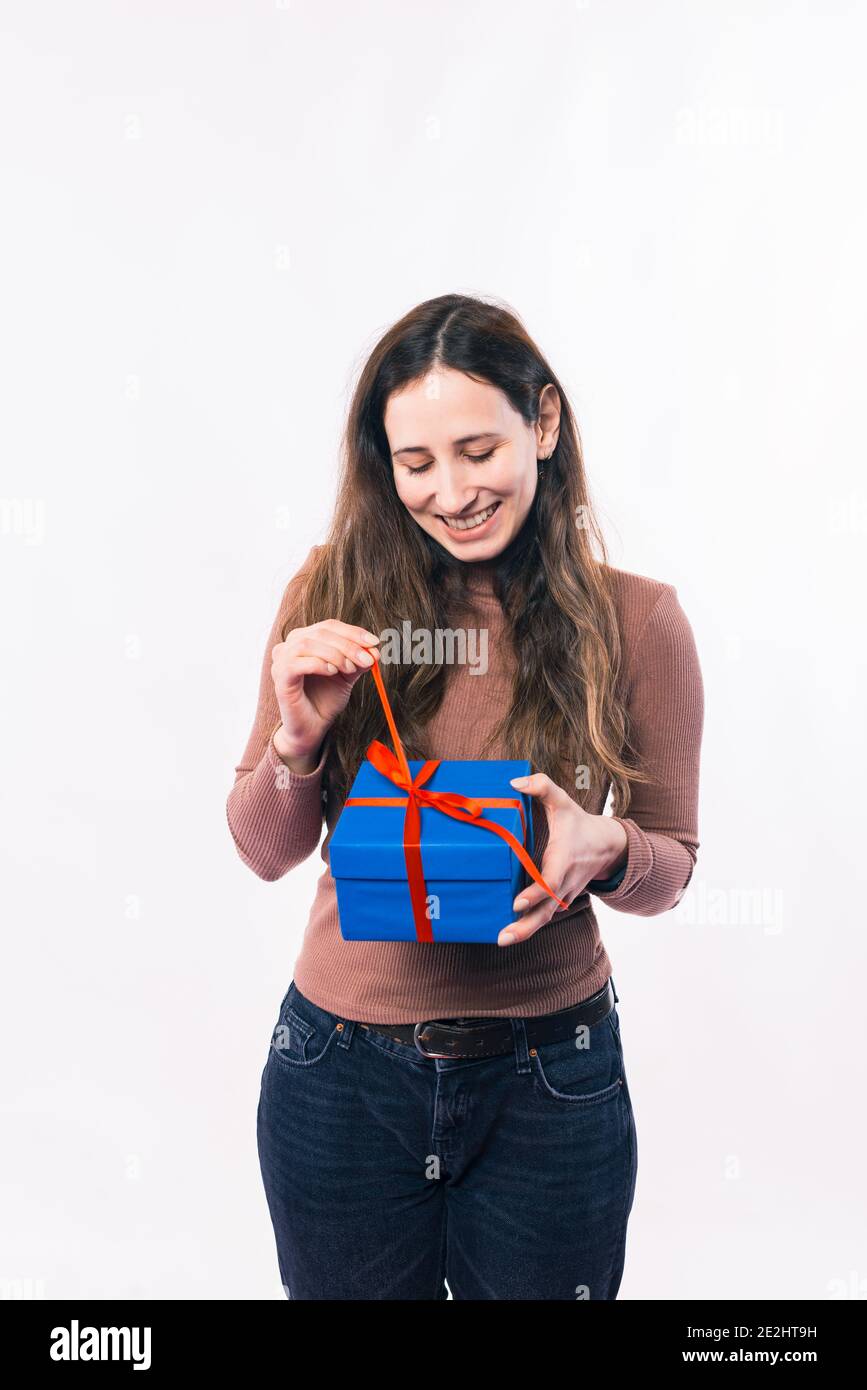 Cheerful young woman opening gift box over white background Stock Photo ...