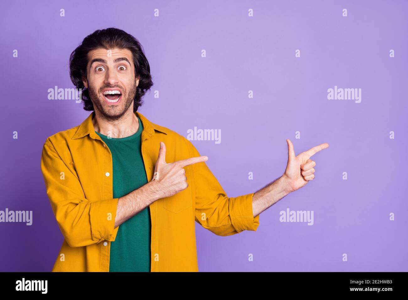 Photo portrait of shocked screaming man pointing two fingers at blank ...