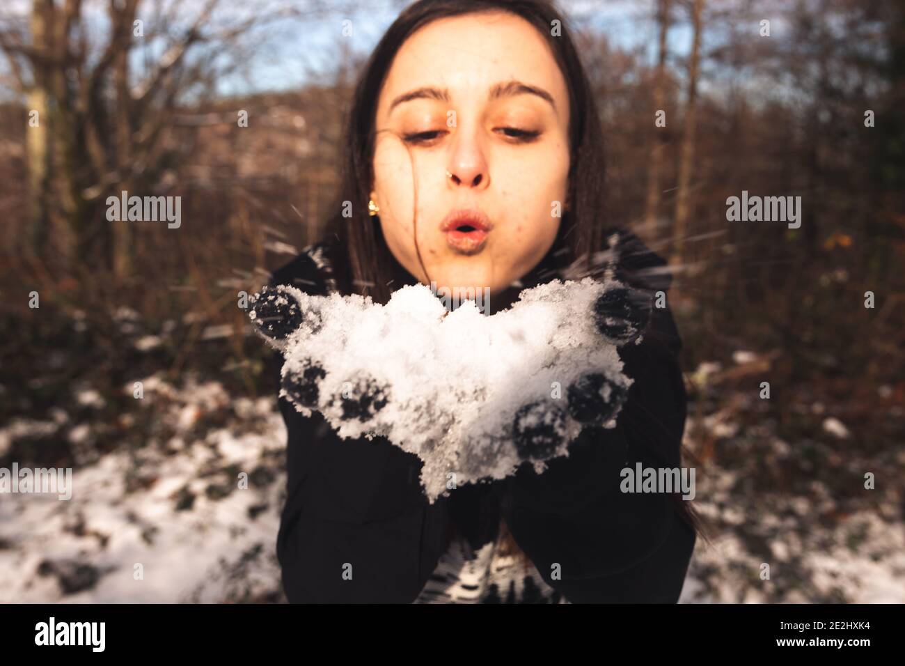 Young woman blowing snow on her hands Stock Photo - Alamy