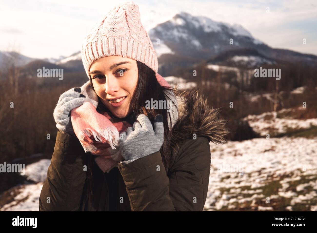 Young woman portrait on a winter landscape well wrapped up for cold ...