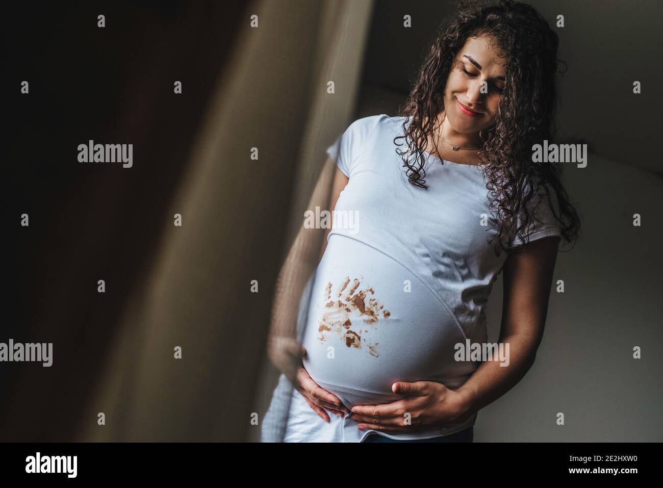 Pregnant woman at the window with chocolate handprint from her 1st ...