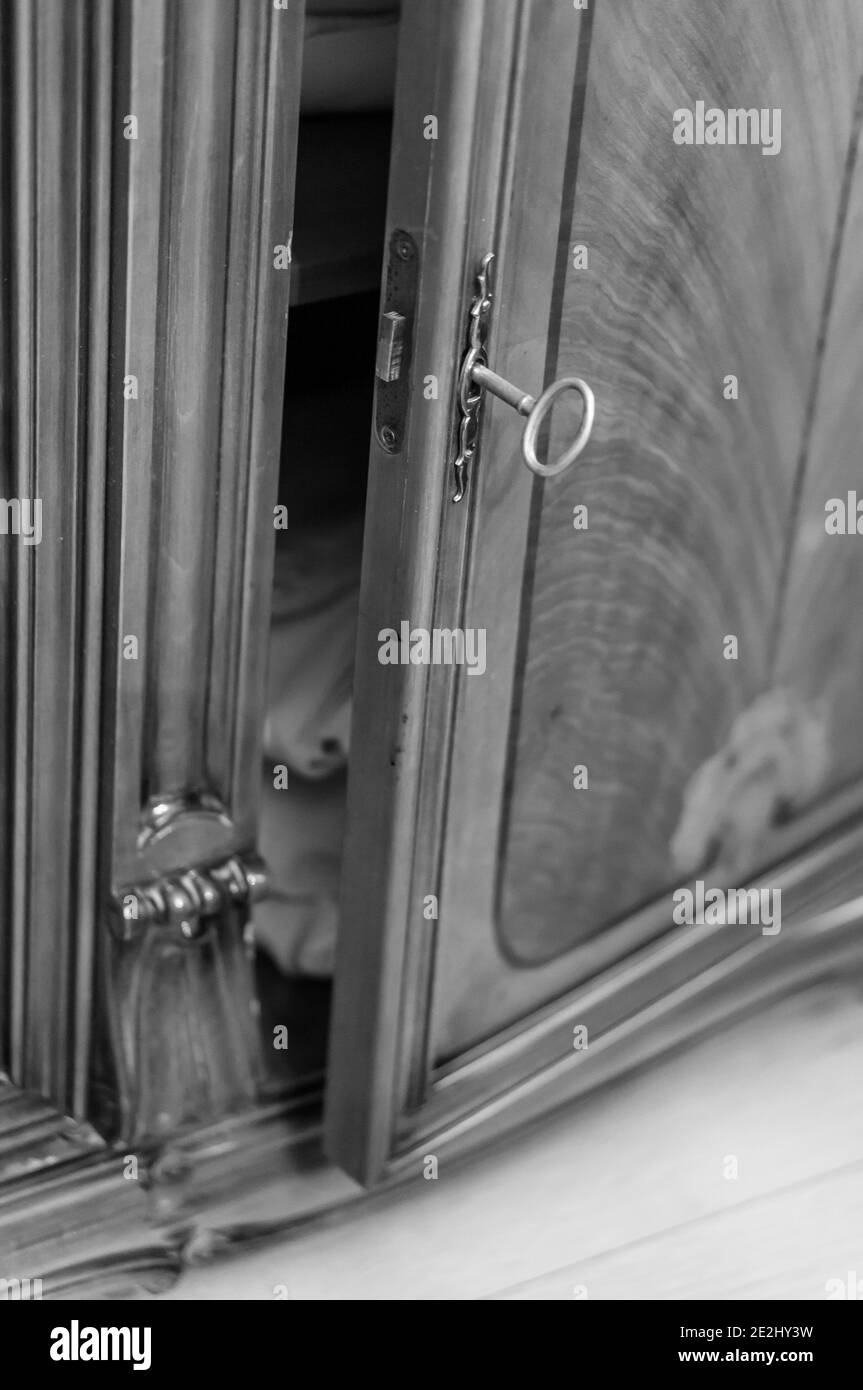 Vertical grayscale shot of a key on a furniture door lock Stock Photo ...