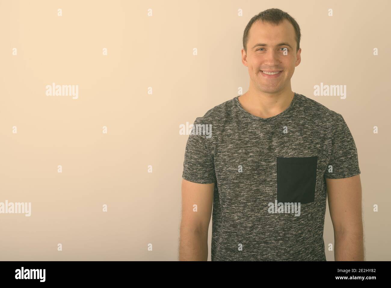 Studio shot of young happy muscular man smiling against white ...