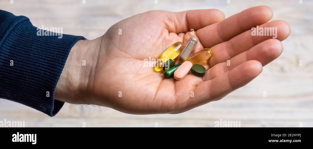 Vitamins and dietary supplements in a hand. Selective focus. People ...
