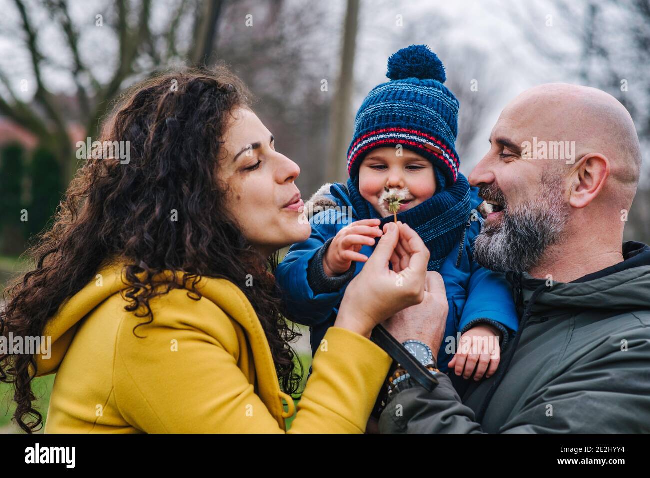 Family having fun outdoors blowing flowers Stock Photo - Alamy