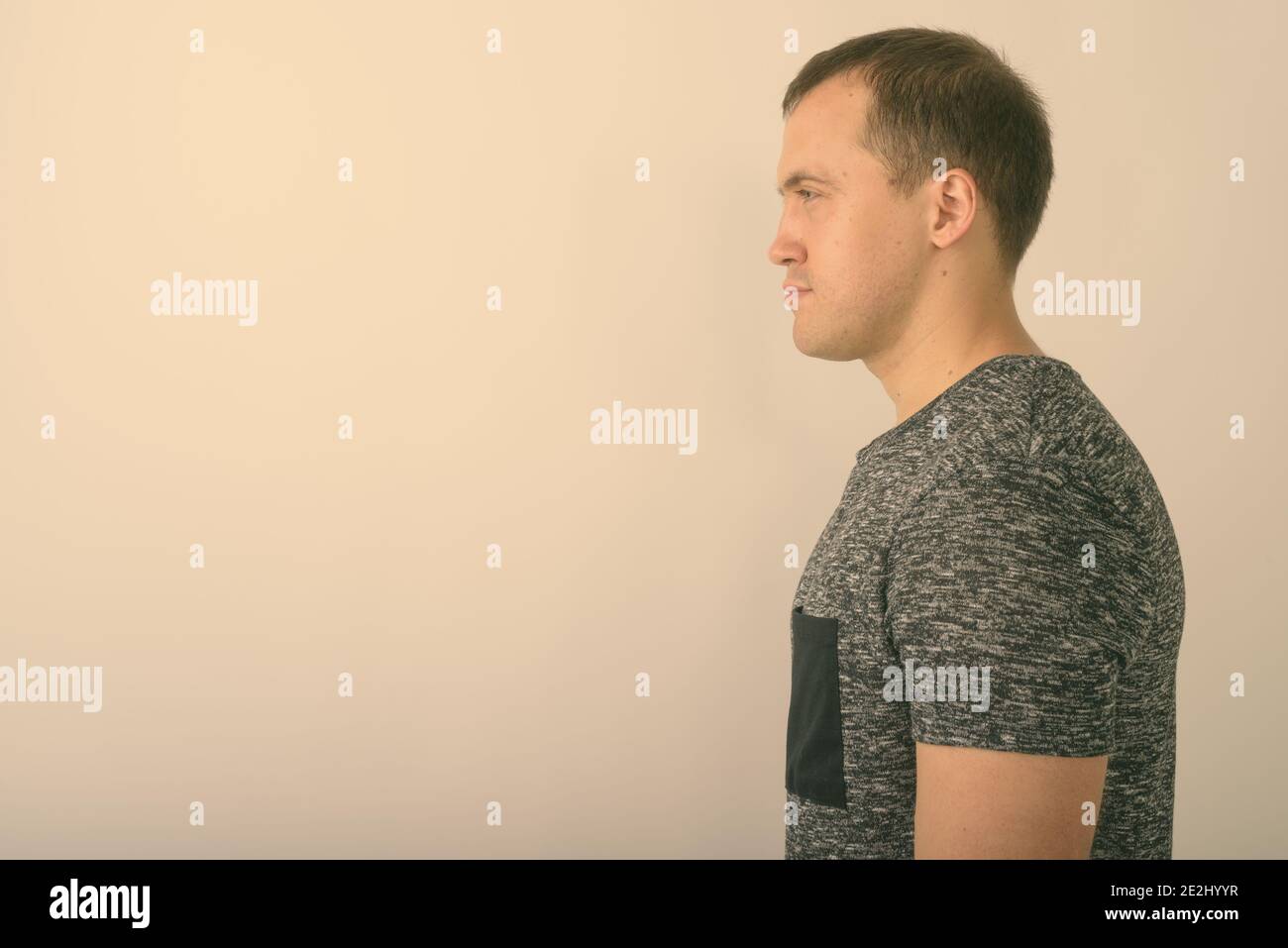 Profile view of young muscular man against white background Stock Photo ...