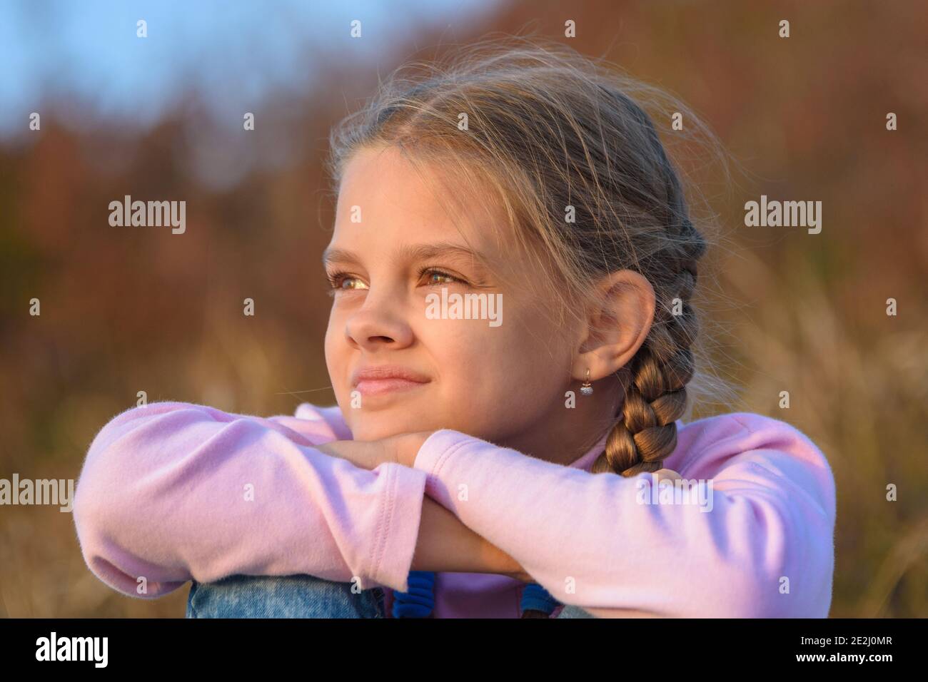 Portrait of a beautiful ten-year-old girl looking at the sunset, close ...