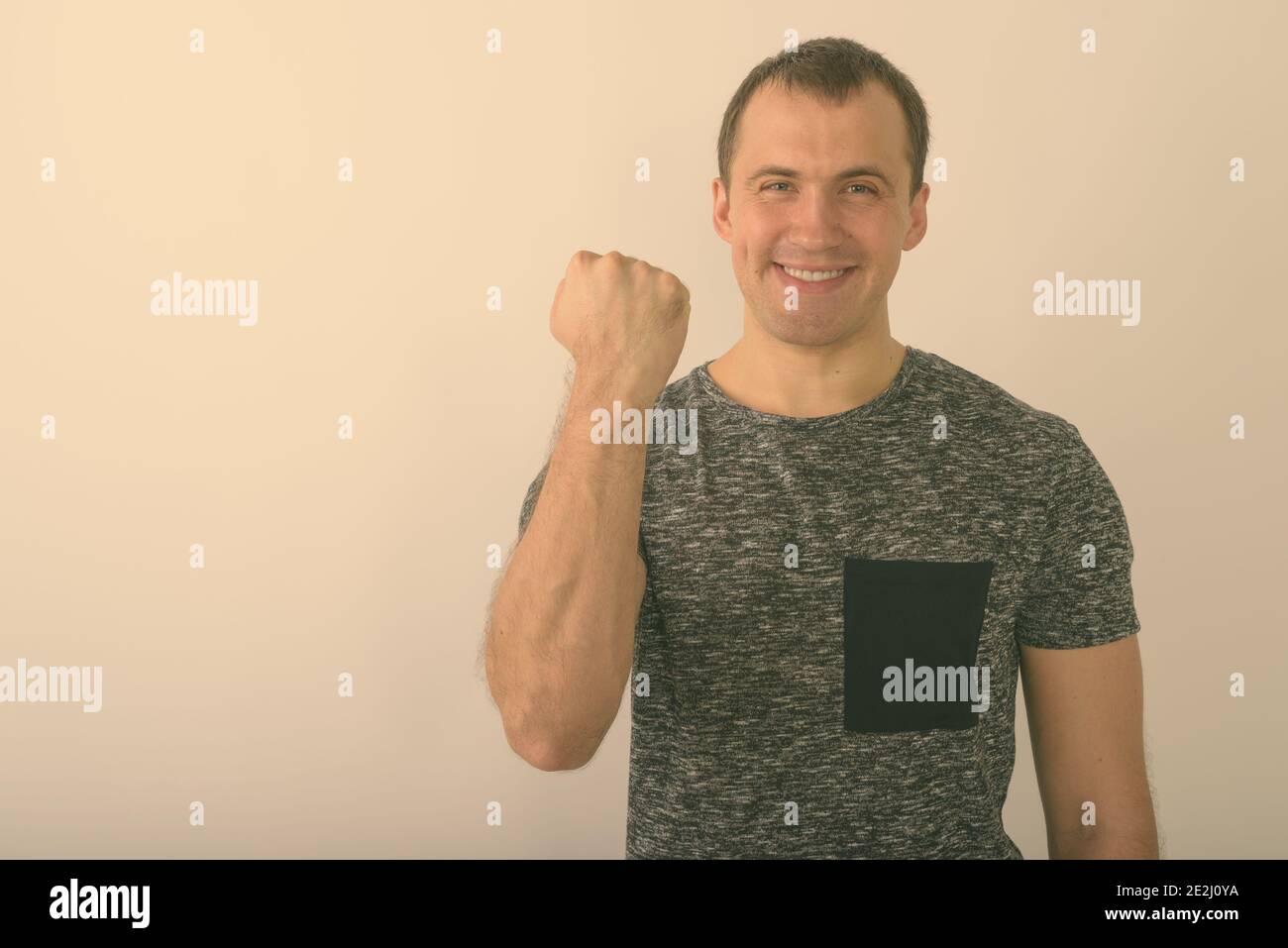 Studio shot of young happy muscular man smiling while looking motivated ...
