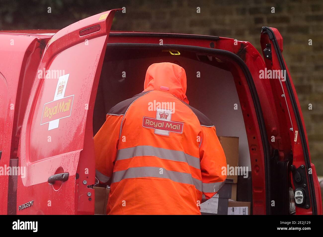 A Royal Mail postal worker preparers to deliver the mail at his van in ...