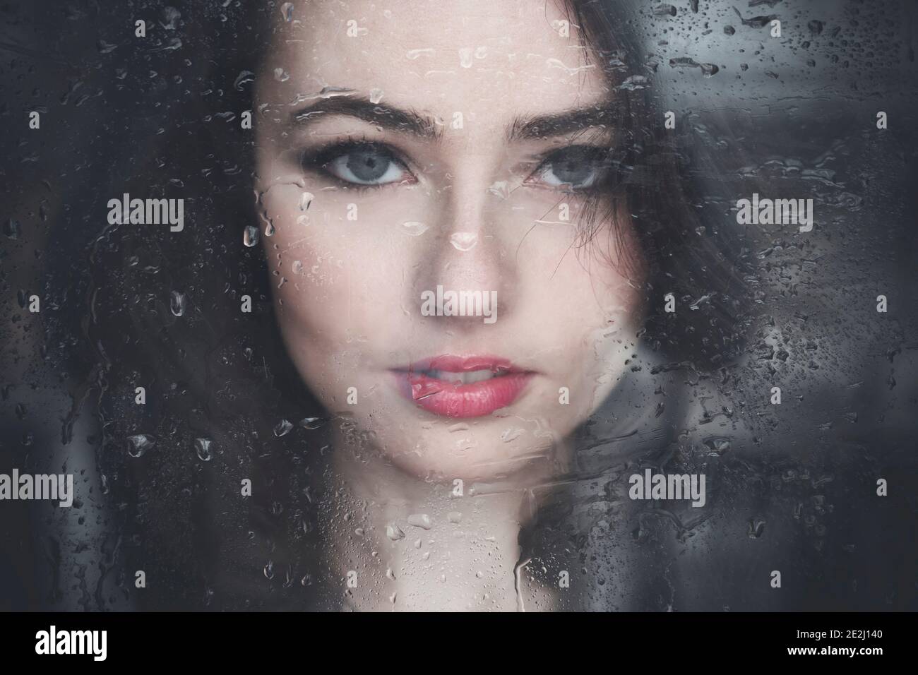 Portrait of a beautiful young woman behind a window Stock Photo - Alamy