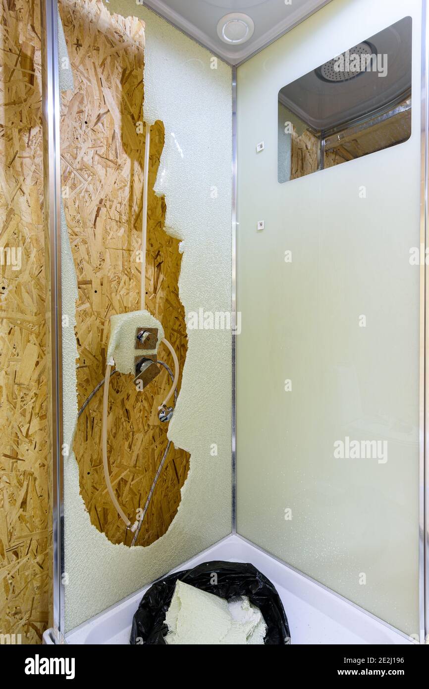 The back window of the shower stall is broken, and there's a bag of ...