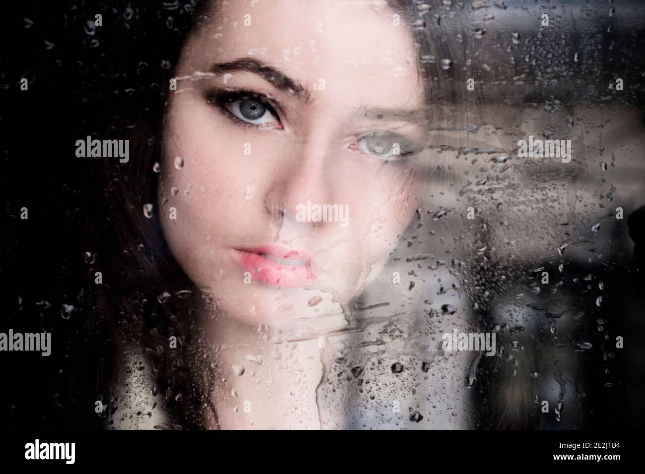 Portrait of a beautiful young woman behind a window Stock Photo - Alamy