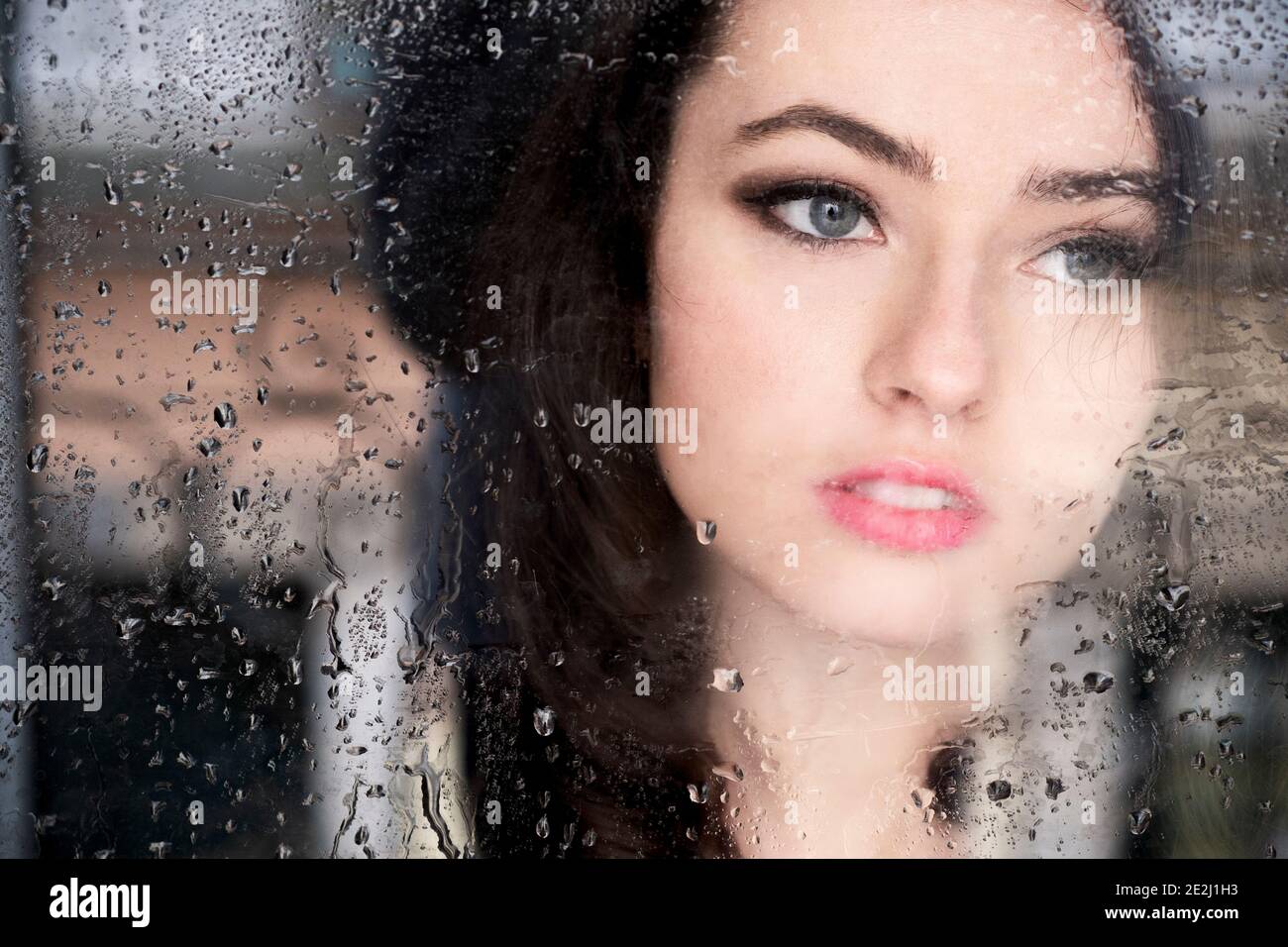 Portrait of a beautiful young woman behind a window Stock Photo - Alamy