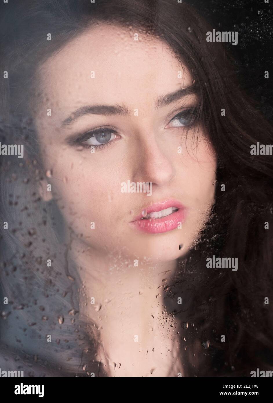 Woman behind glass with drops of water hi-res stock photography and ...