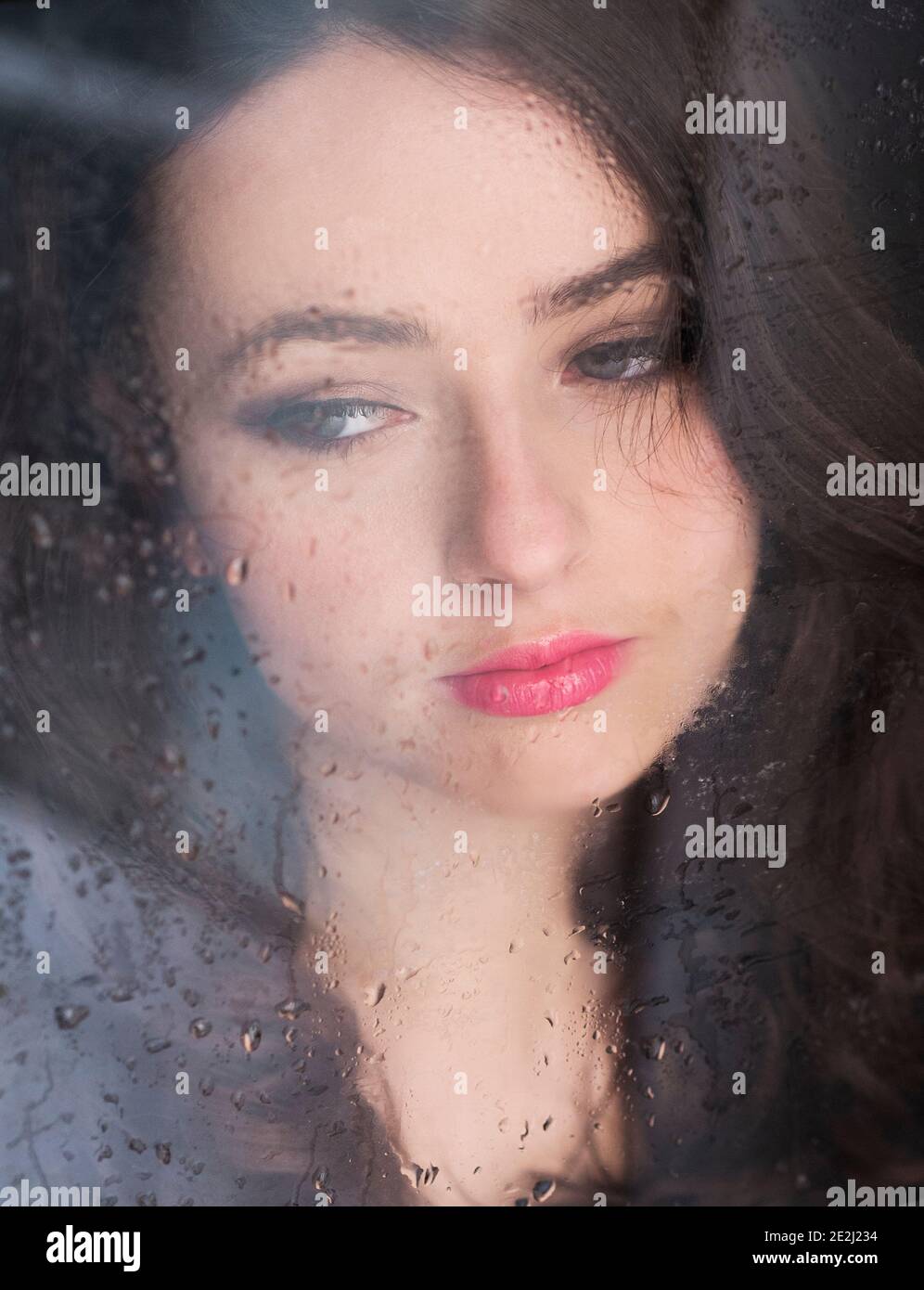 Portrait of a beautiful young woman behind a window Stock Photo - Alamy