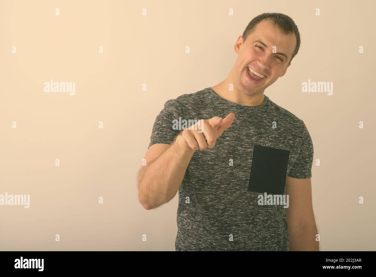 Studio shot of young happy muscular man smiling and laughing while ...