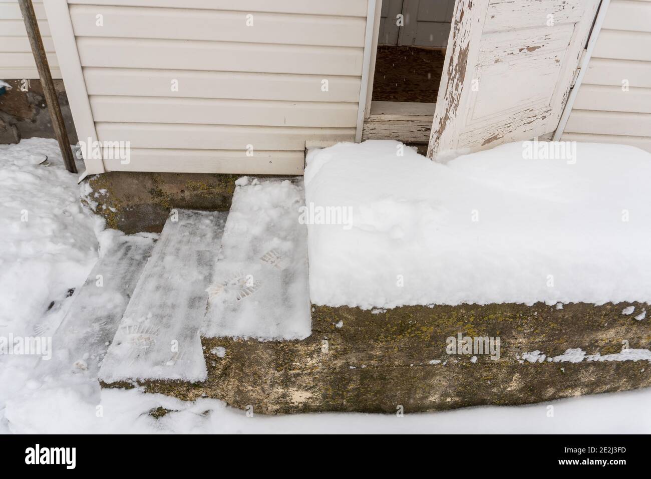 Concrete porch cleared of snow in winter and open antique door, country ...