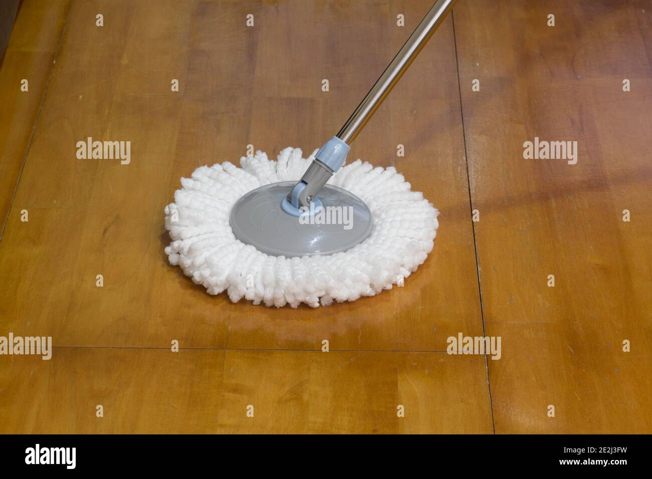 Gray cleaning mop on wooden floor background Stock Photo - Alamy