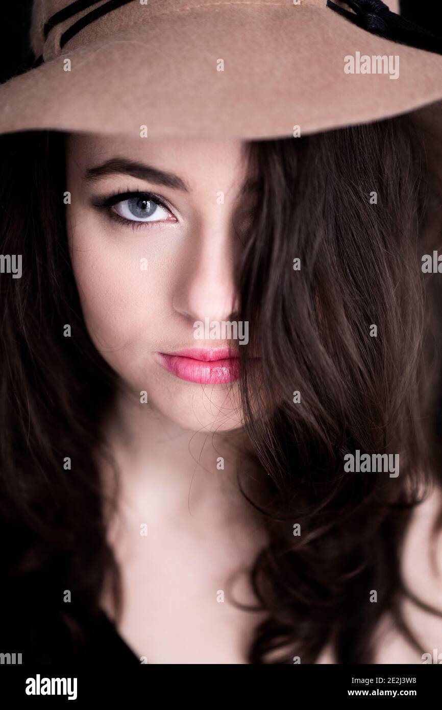 Portrait of a beautiful young woman with hair covering half of her face ...