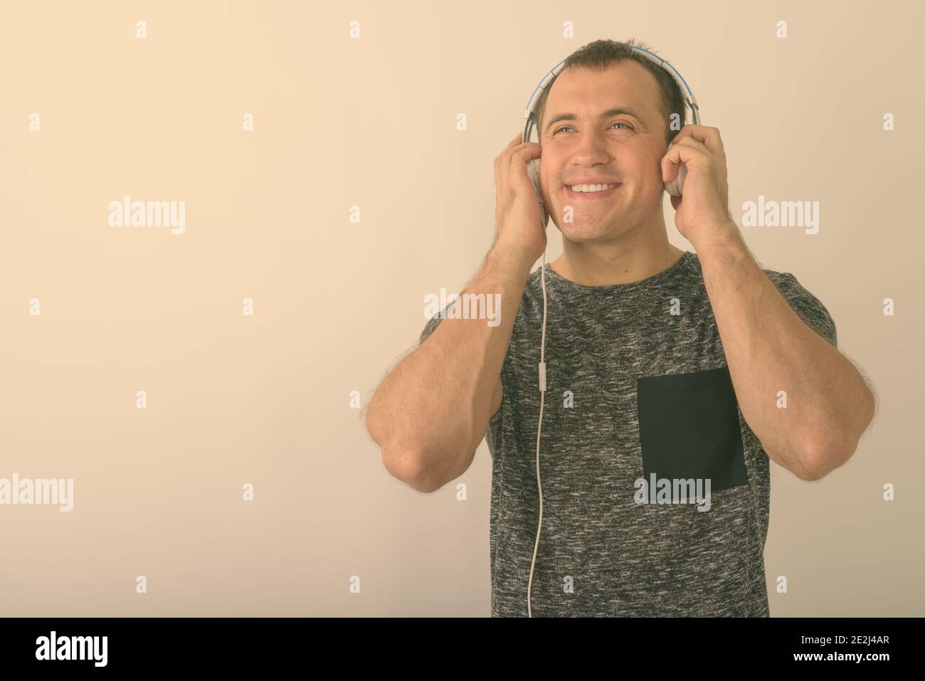 Studio shot of young happy muscular man smiling while thinking and ...