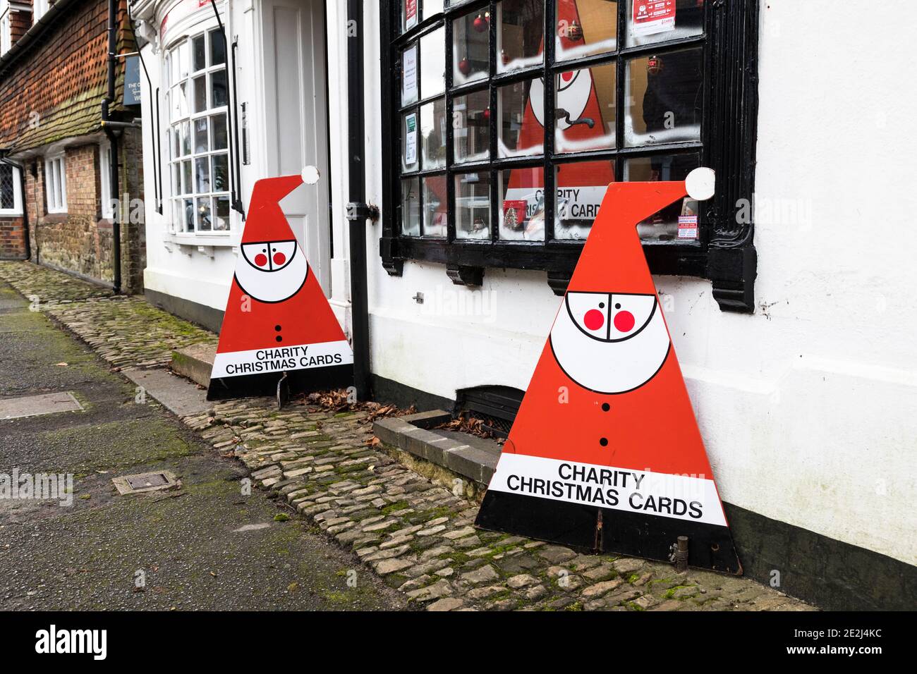 Father Christmas signs for charity Christmas cards outside a shop Stock ...