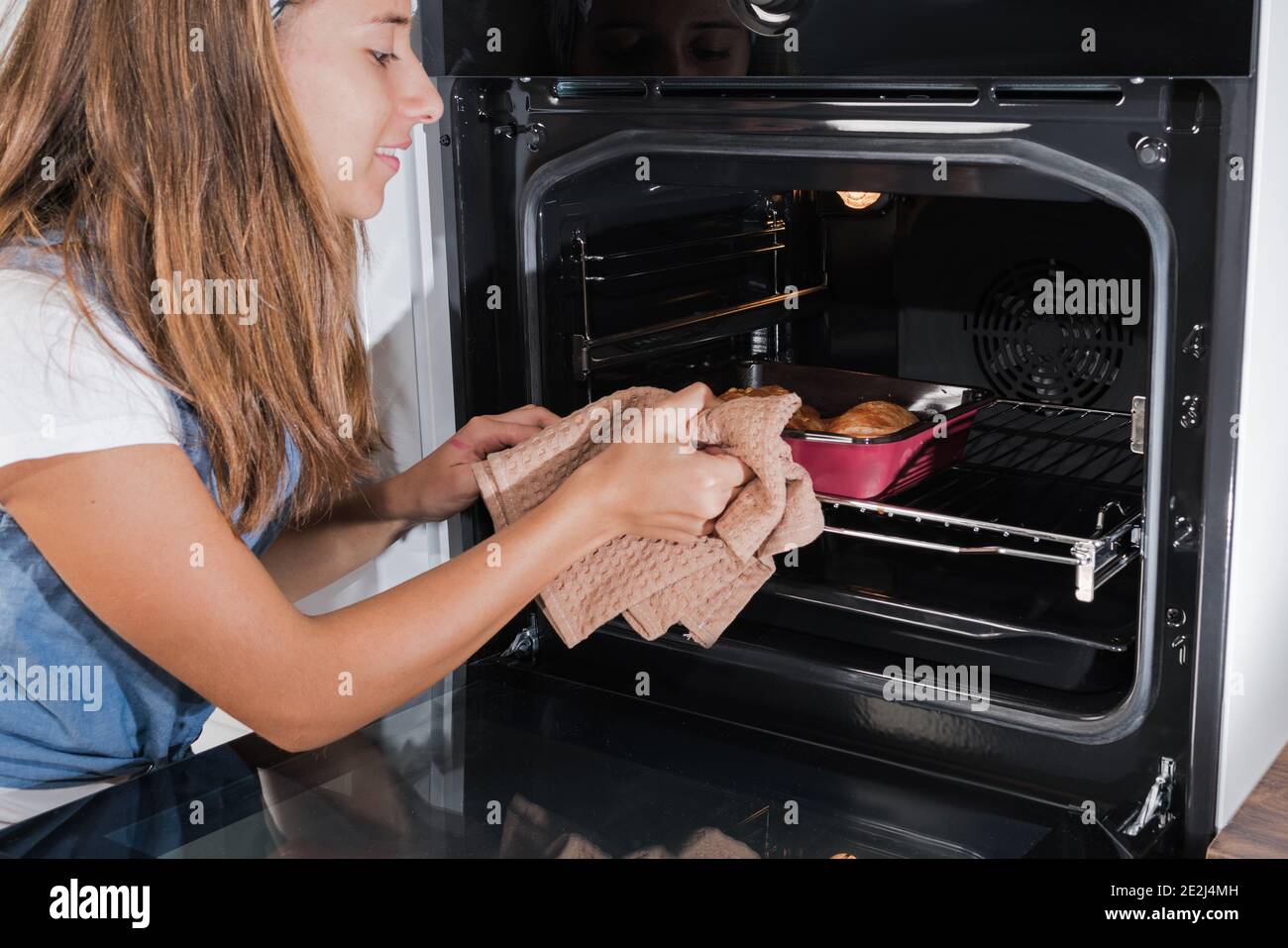 The girl puts the grilled chicken in the oven packaging in the oven ...
