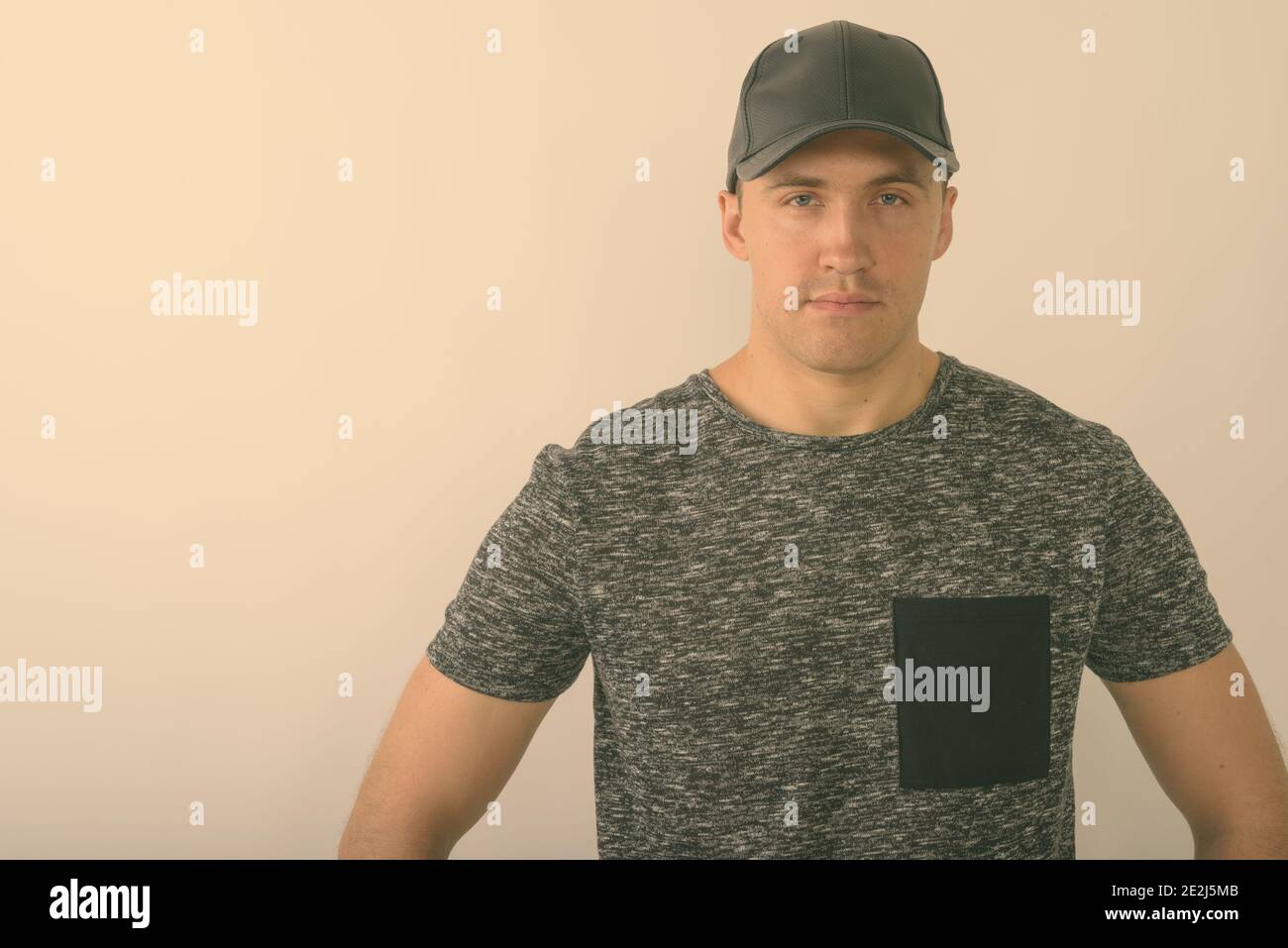 Close up of young muscular man wearing cap against white background ...