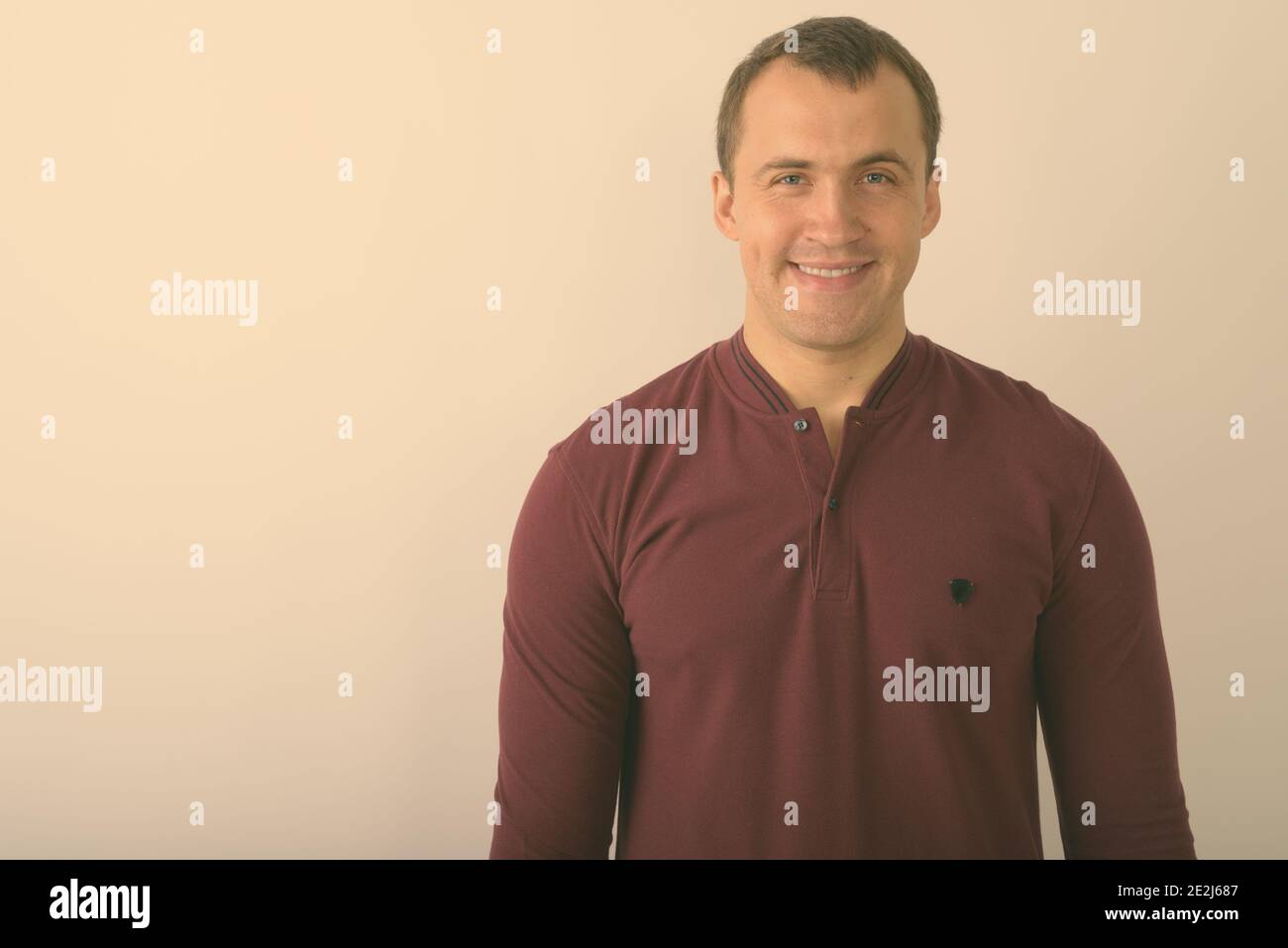 Studio shot of young happy muscular man smiling against white ...