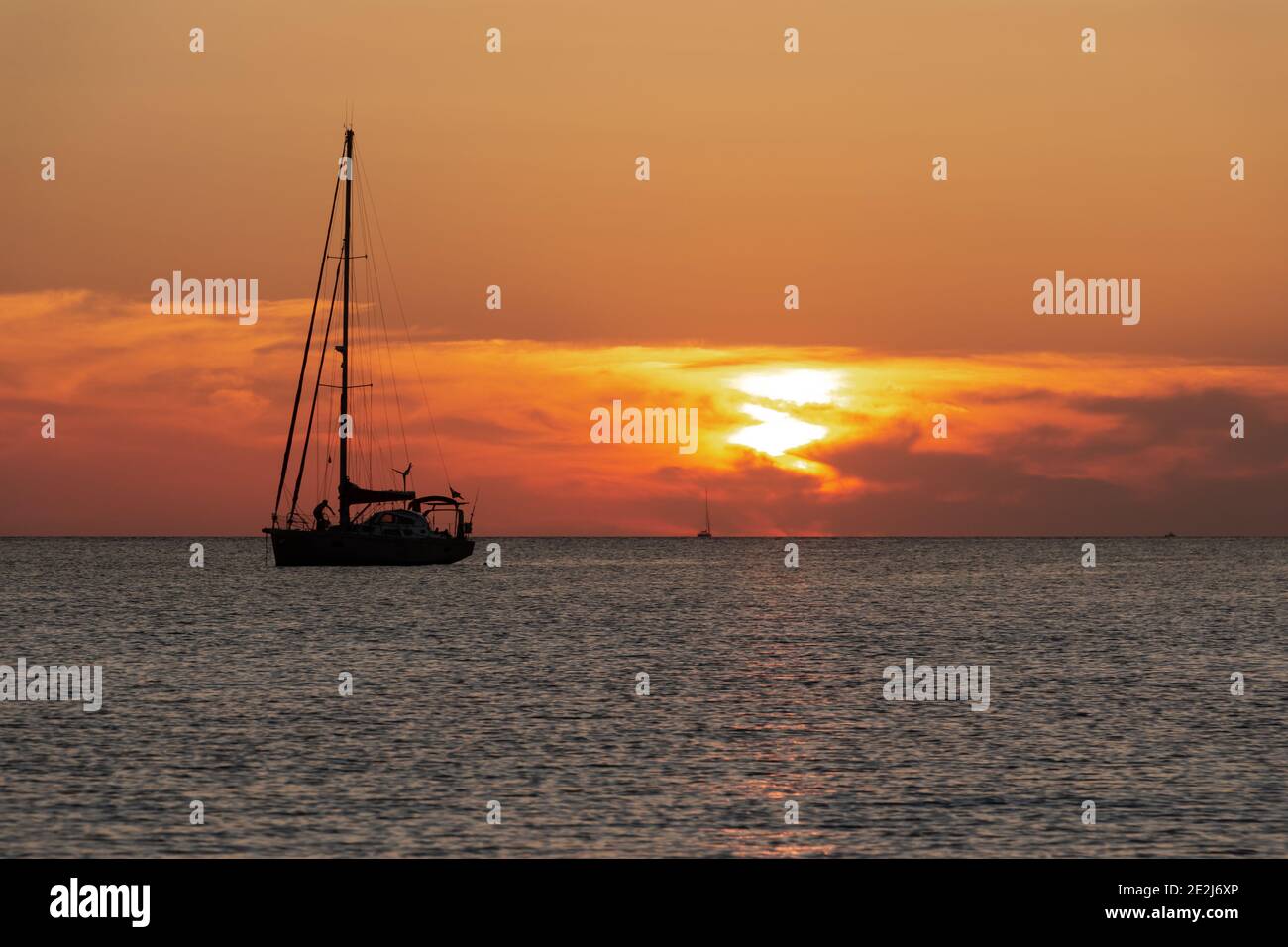 Seascape of silhouette of a sailing ship in the ocean at sunset ...