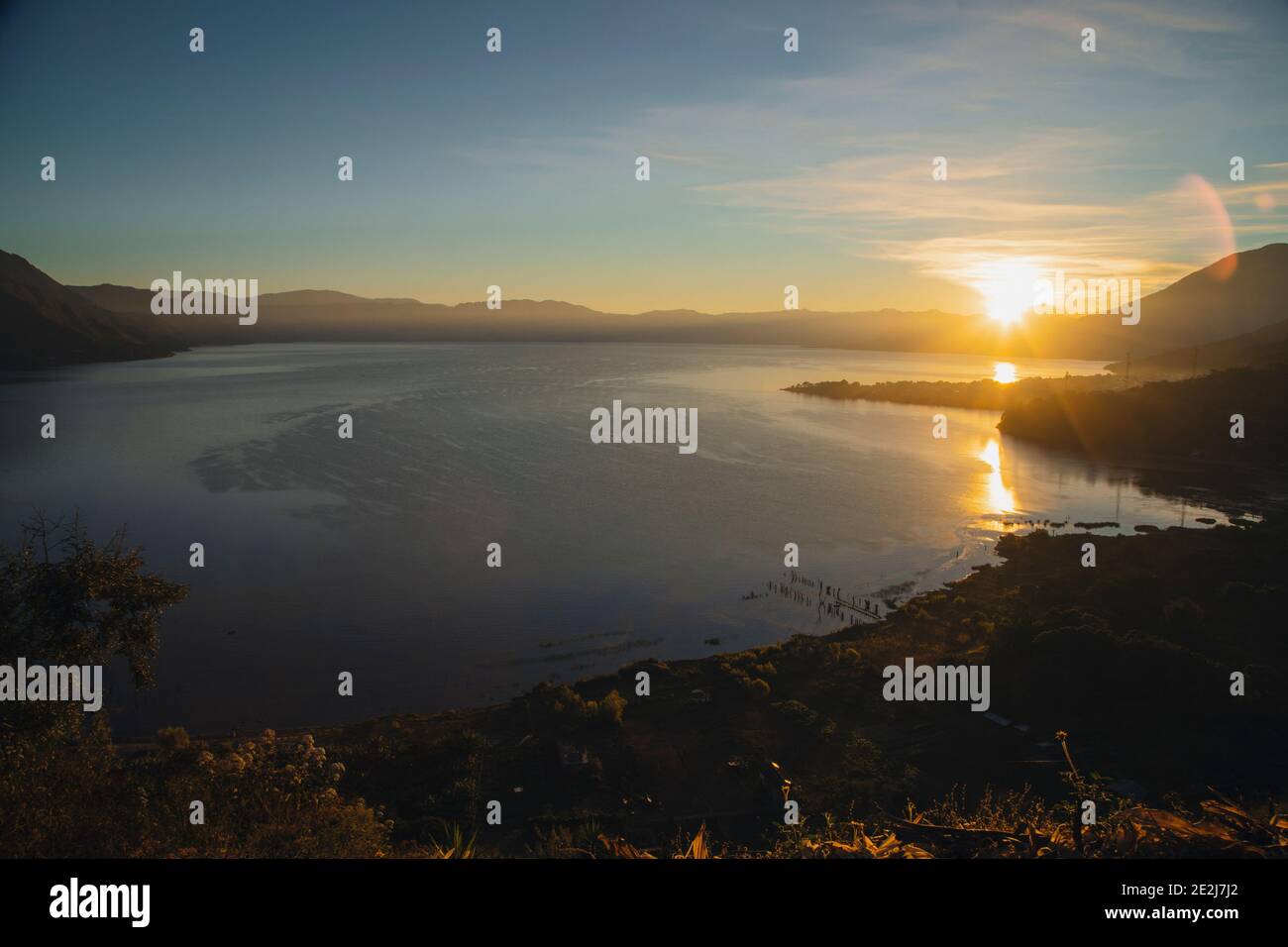 Sunrise on Lake Atitlán the sun rising behind the mountains and ...