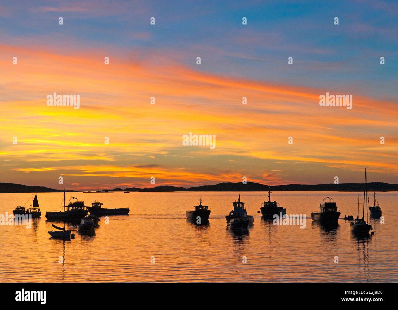 A rich sunset out to sea lighting up the water to an orange pink Isles ...