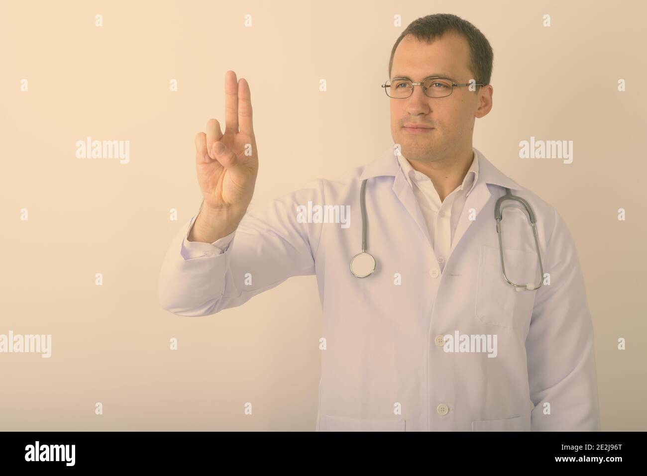 Studio shot of young muscular man doctor thinking while touching ...