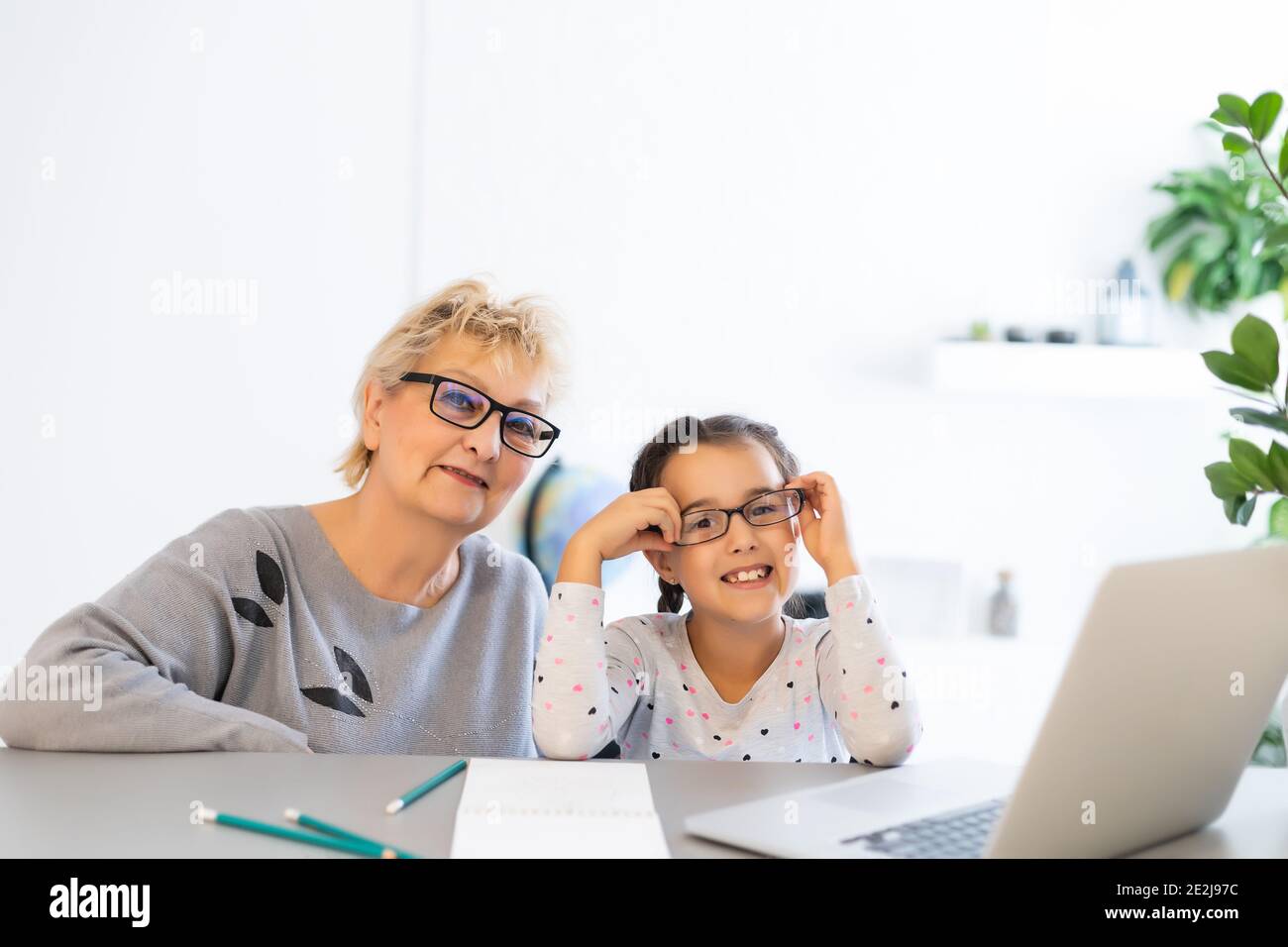 Cute and happy little girl child using laptop computer with her grandma ...