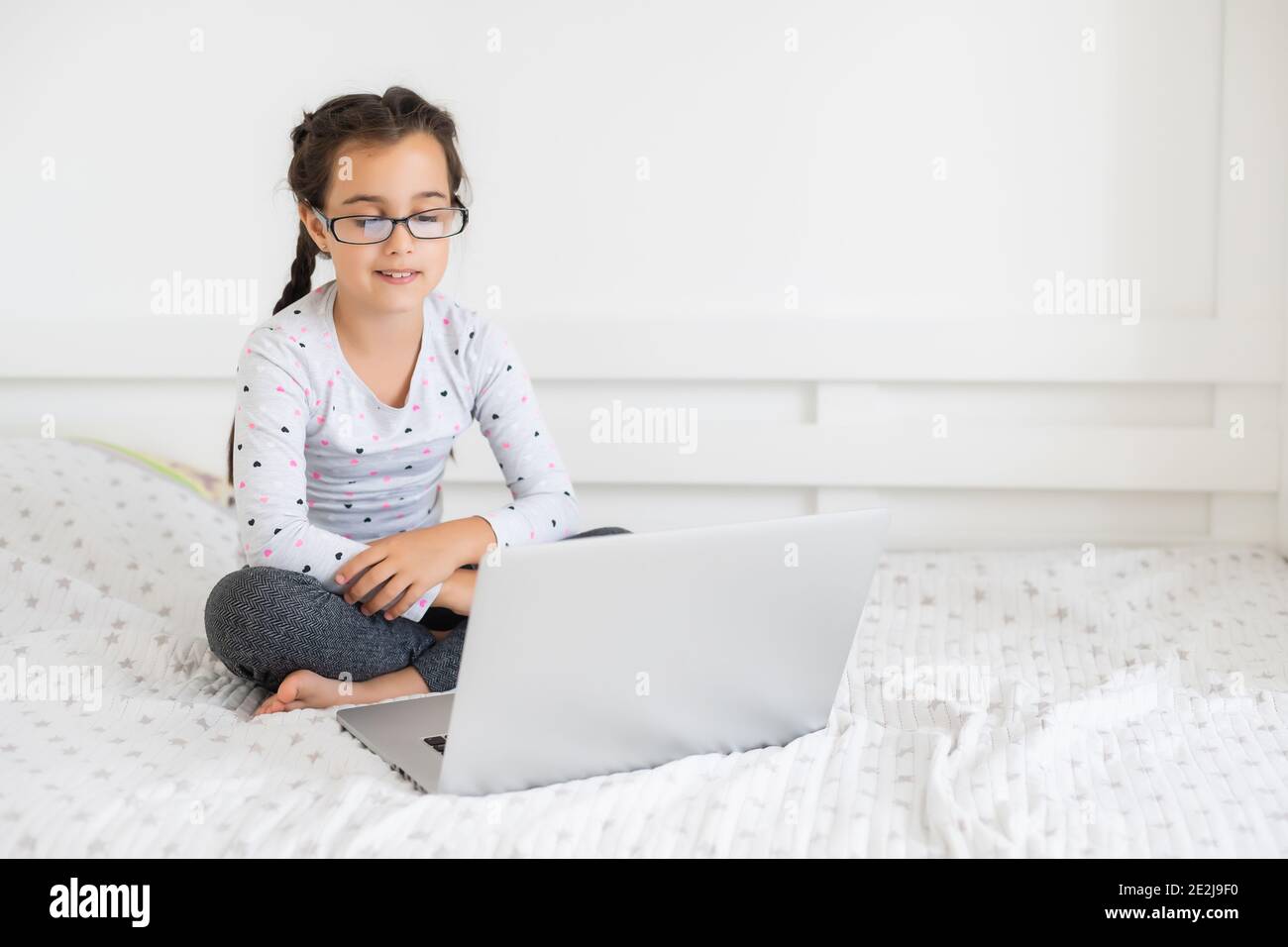 Happy little girl at home working with a laptop Stock Photo - Alamy