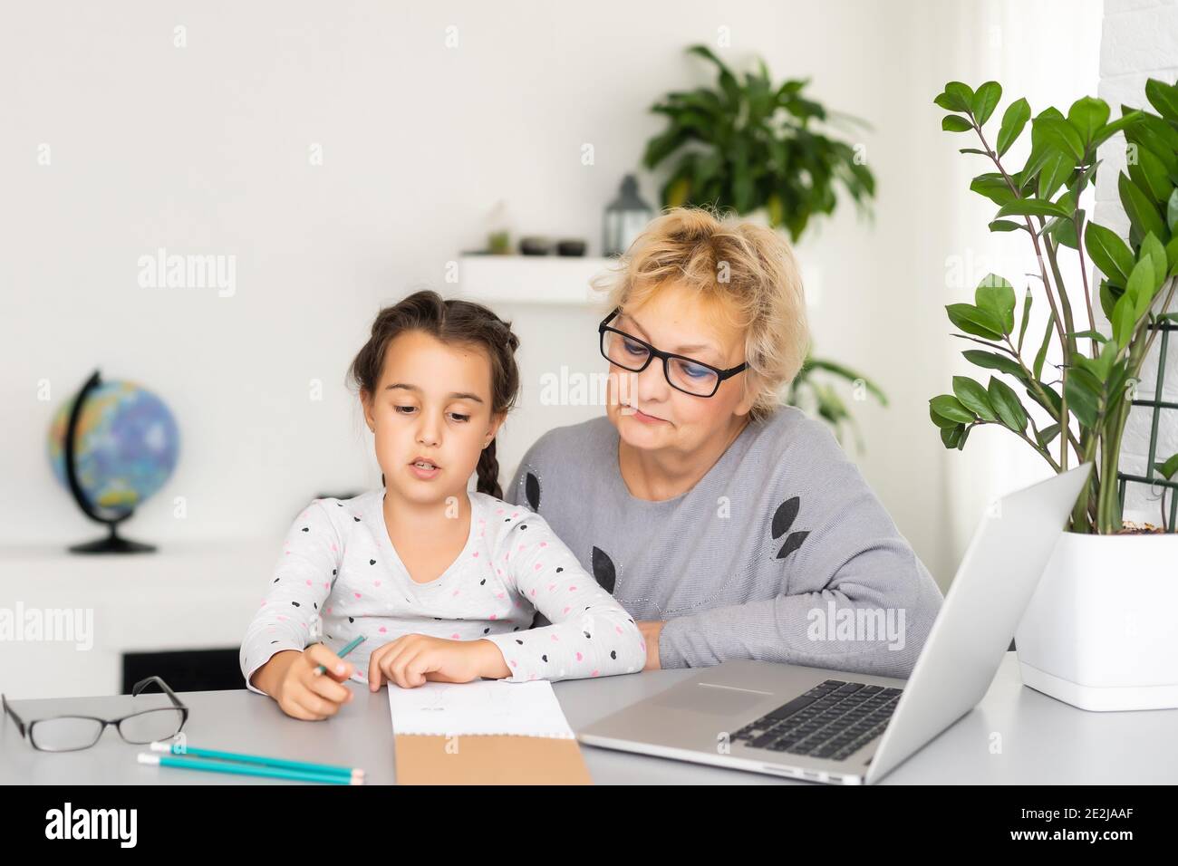 Cute and happy little girl child using laptop computer with her grandma ...