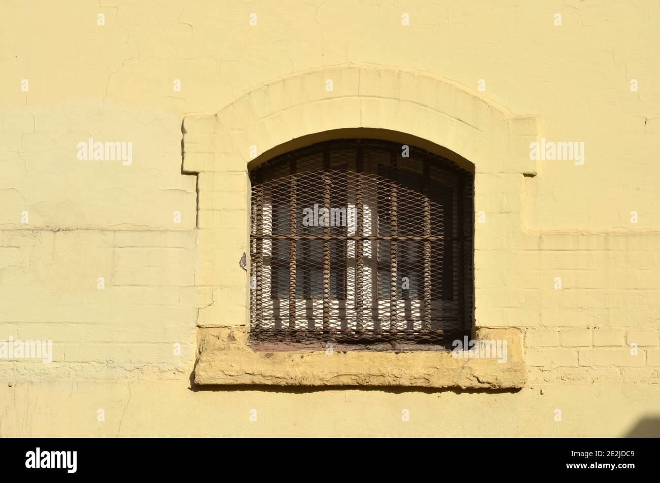 Yellow painted wall and prison window Stock Photo - Alamy