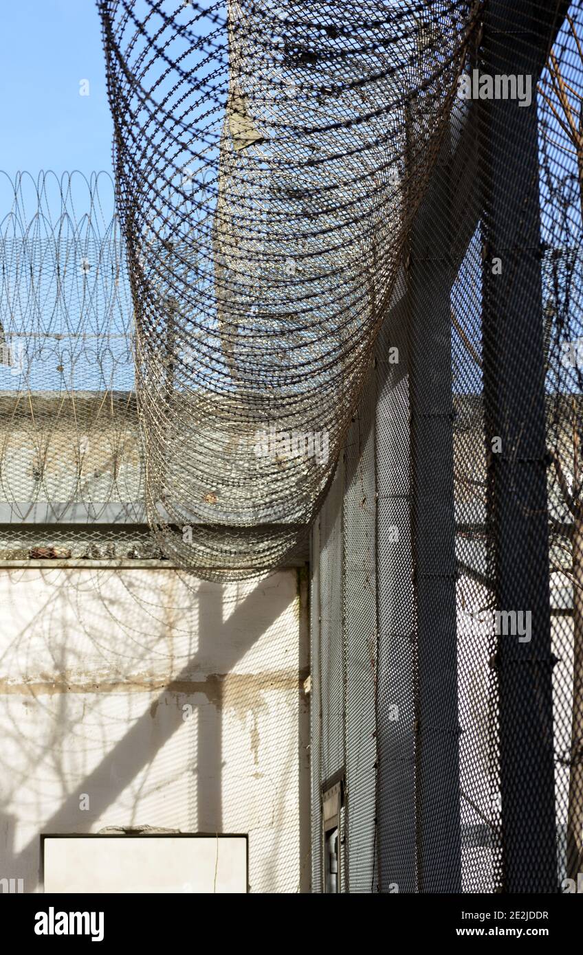 Yard inside a jail with fences and heavy barbwire Stock Photo - Alamy