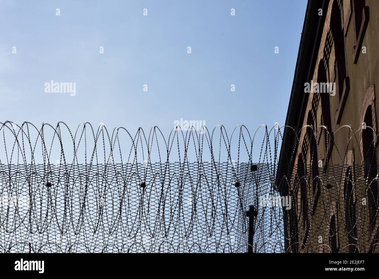 Barbed wire on a wall in a prison Stock Photo - Alamy