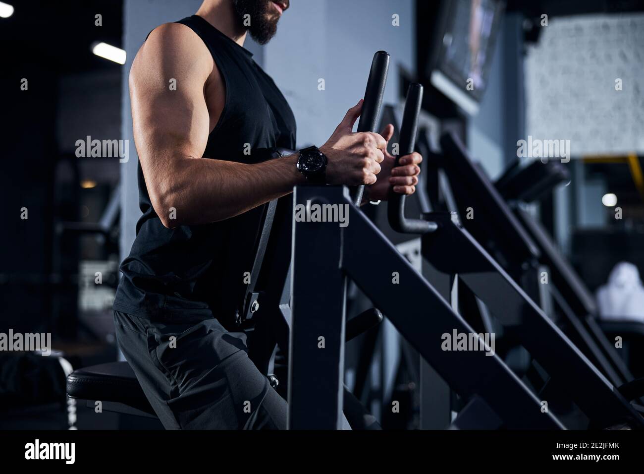 Male athlete moving the handles of a weight-lifting machine Stock Photo ...