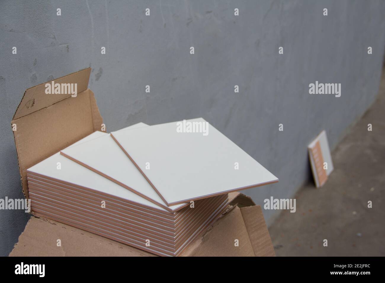 Laying Ceramic Tiles on the wall. White ceramic tiles. Renovation work ...