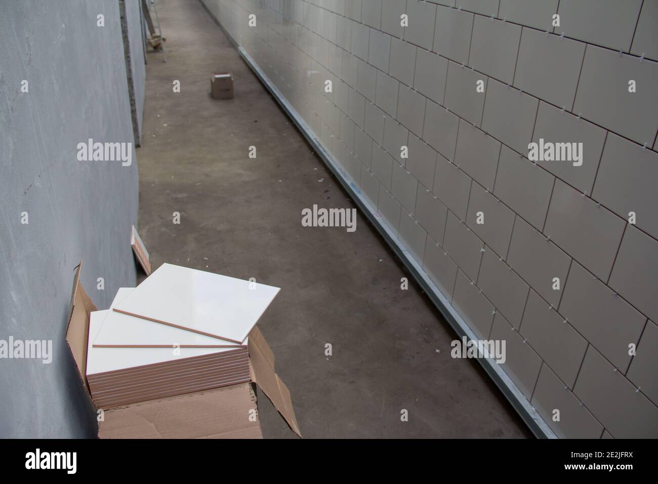 Laying Ceramic Tiles on the wall. White ceramic tiles. Renovation work ...