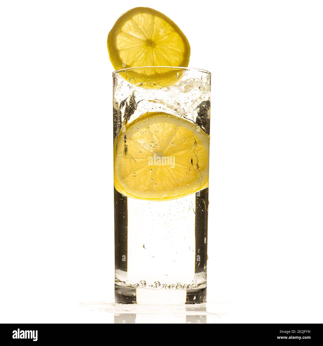 Lemon slice splashing into glass of water Stock Photo - Alamy