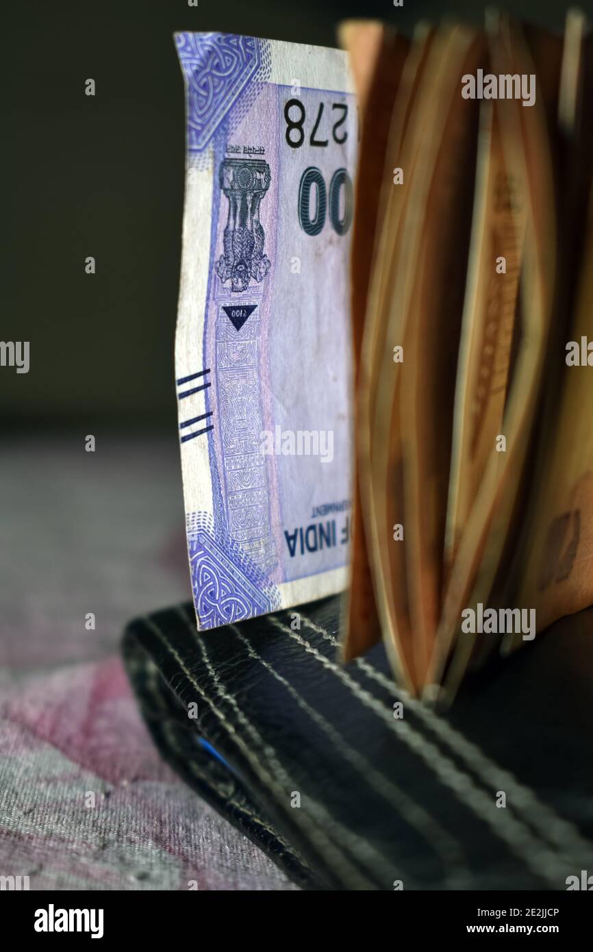 Top view closeup of several Indian rupee banknotes in a leather wallet ...