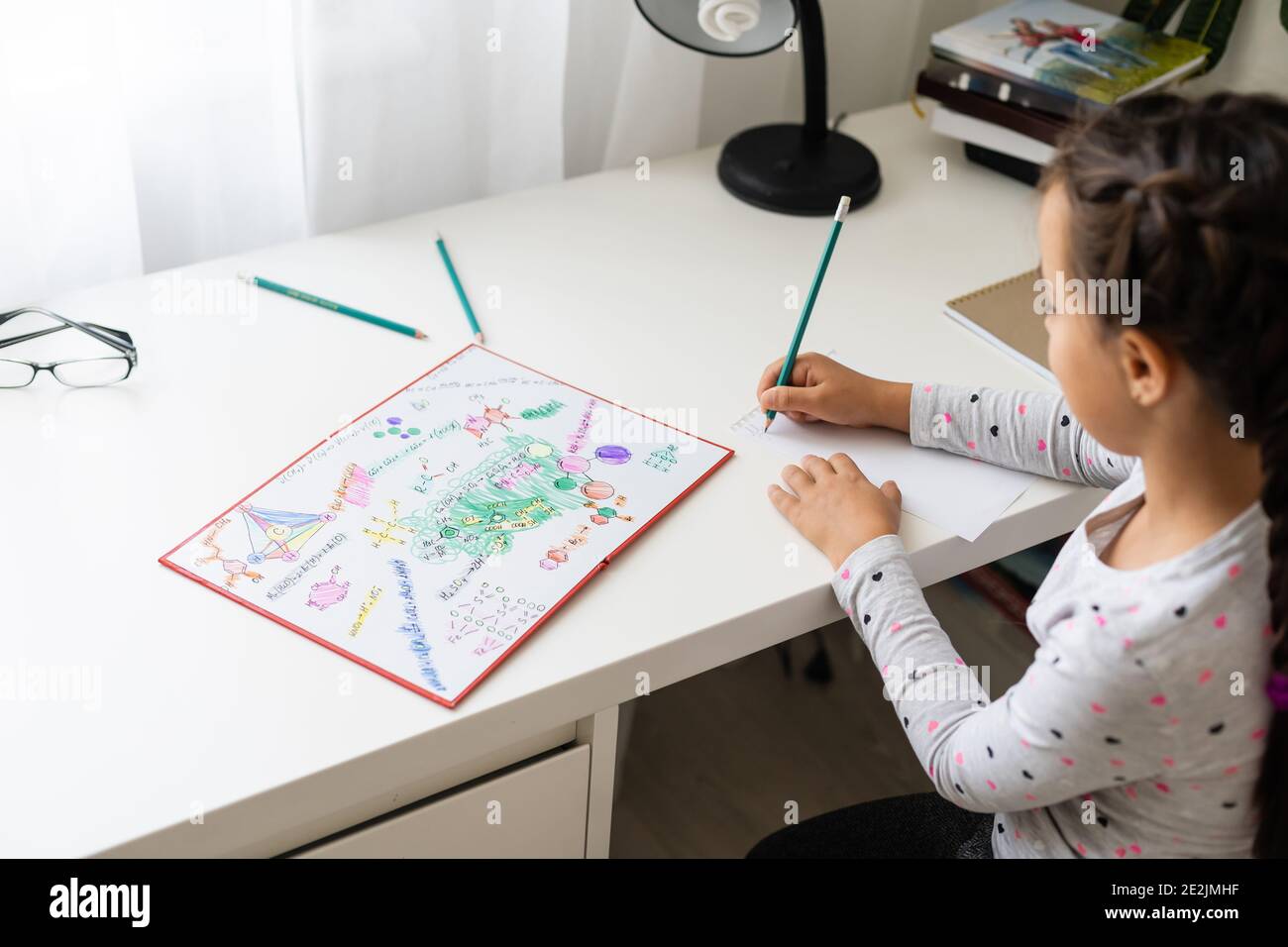 cute happy little girl writing something in her notebook Stock Photo ...