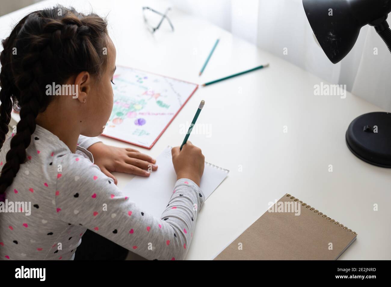 a child girl doing homework writing and reading at home Stock Photo - Alamy