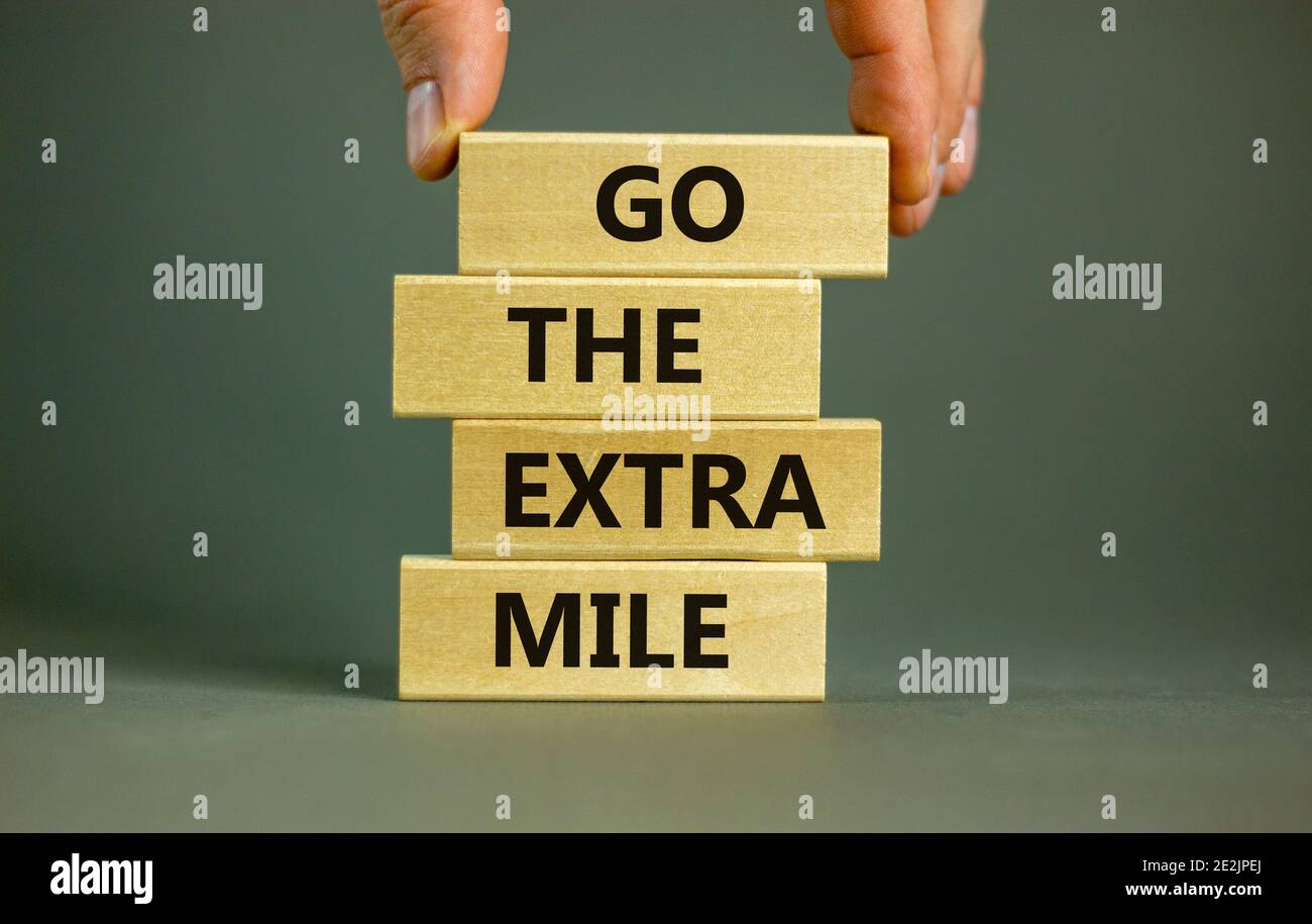 Go the extra mile symbol. Wooden blocks with words 'Go the extra mile ...