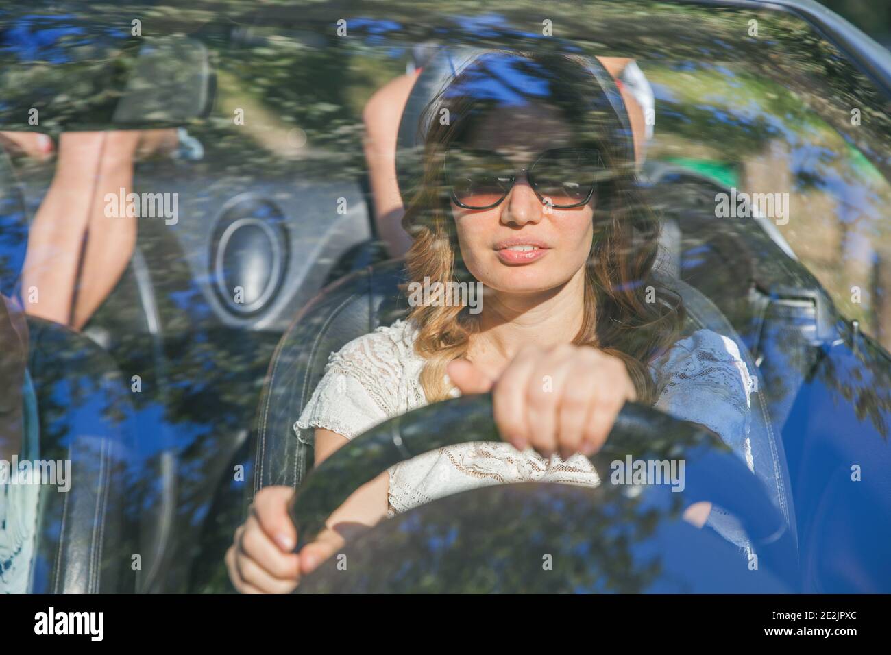 Beautiful woman with sunglasses driving car, looking through windshield ...