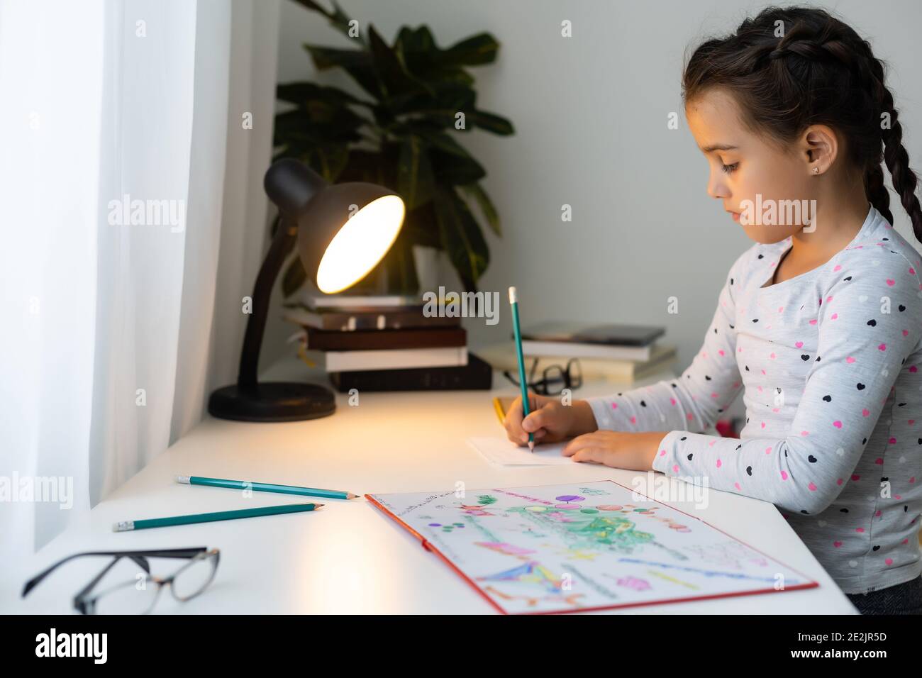 a child girl doing homework writing and reading at home Stock Photo - Alamy